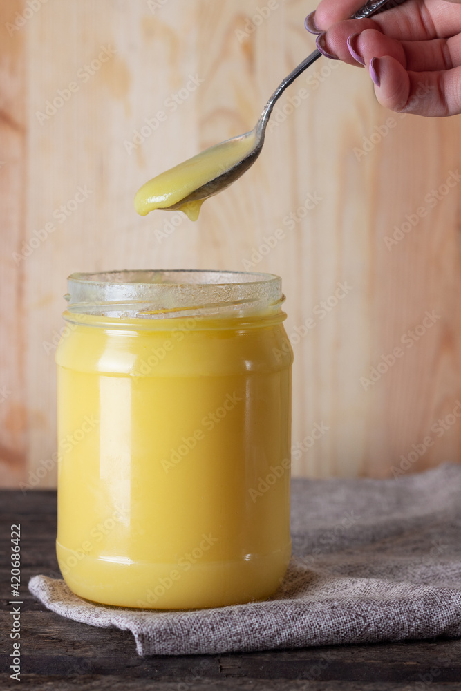 Ghee clarified butter desi in glass jar on natural wooden background ...
