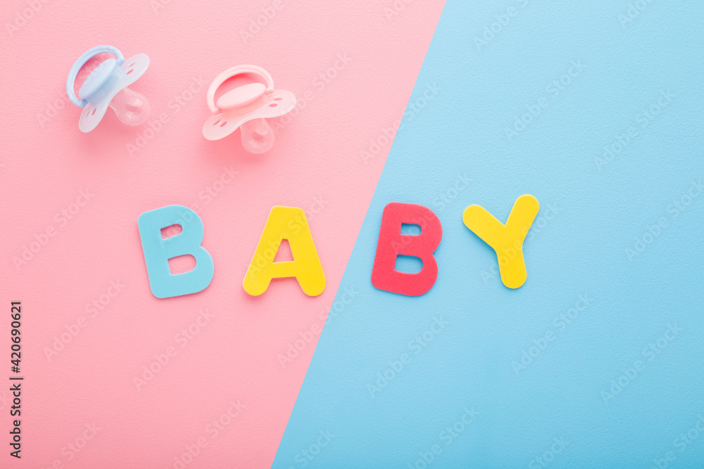 Two silicone soothers and baby word created from colorful letters on ...
