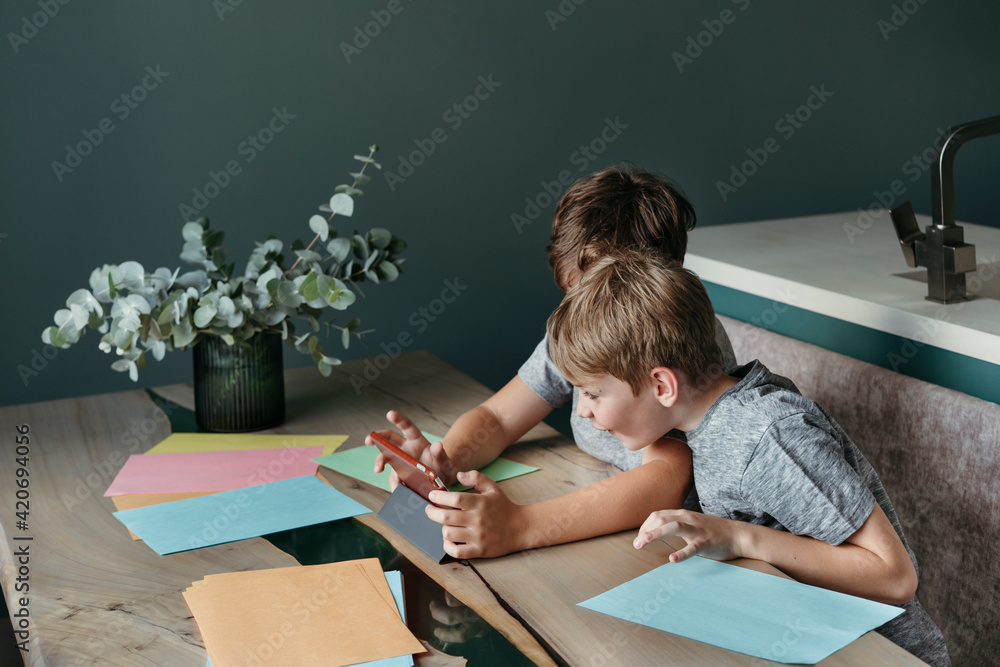 Children make crafts out of paper. Stock Photo | Adobe Stock