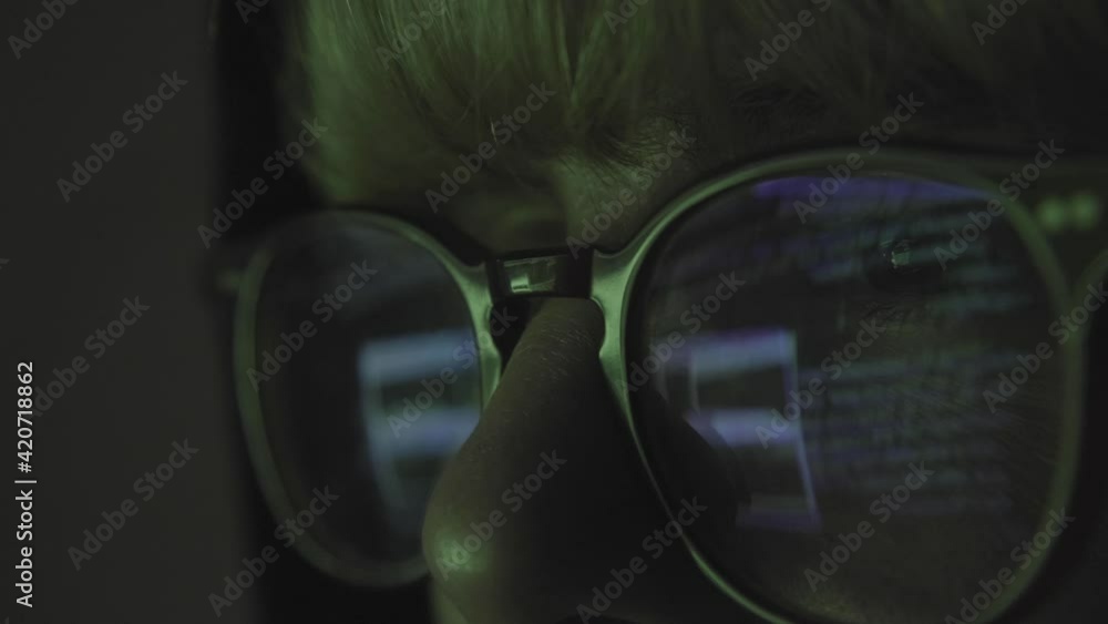 Hacker wearing Glasses Working on Computer, Code is reflected in his ...