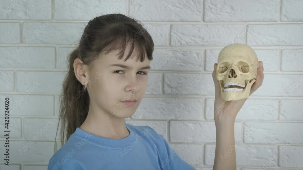 Open mouth with a skull. A cute girl is surprised when the skull opens ...
