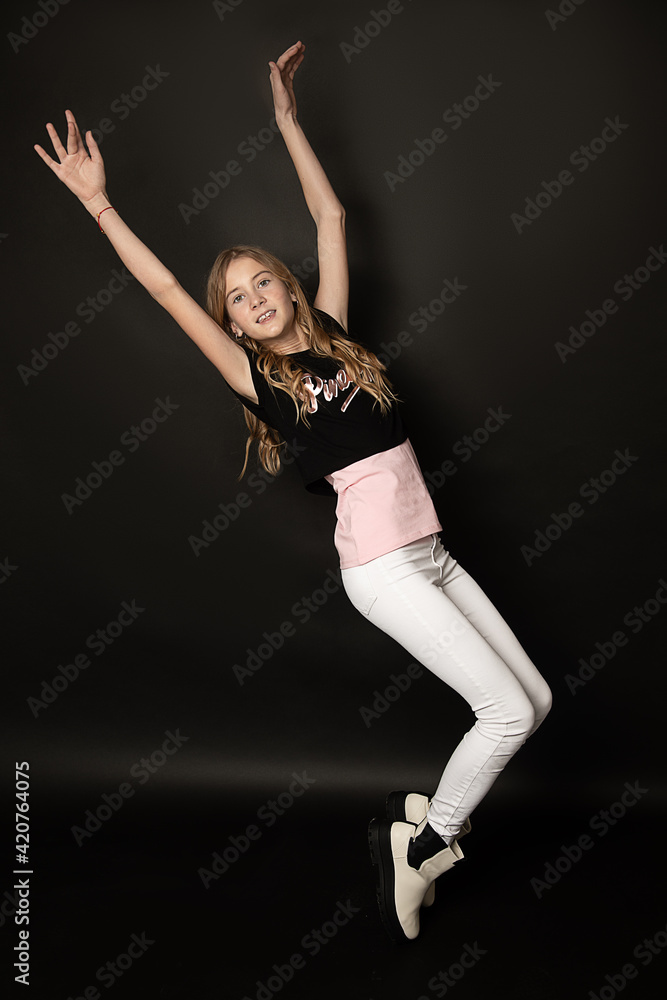Beautiful girl 11 years old dancing or falling on black background in ...
