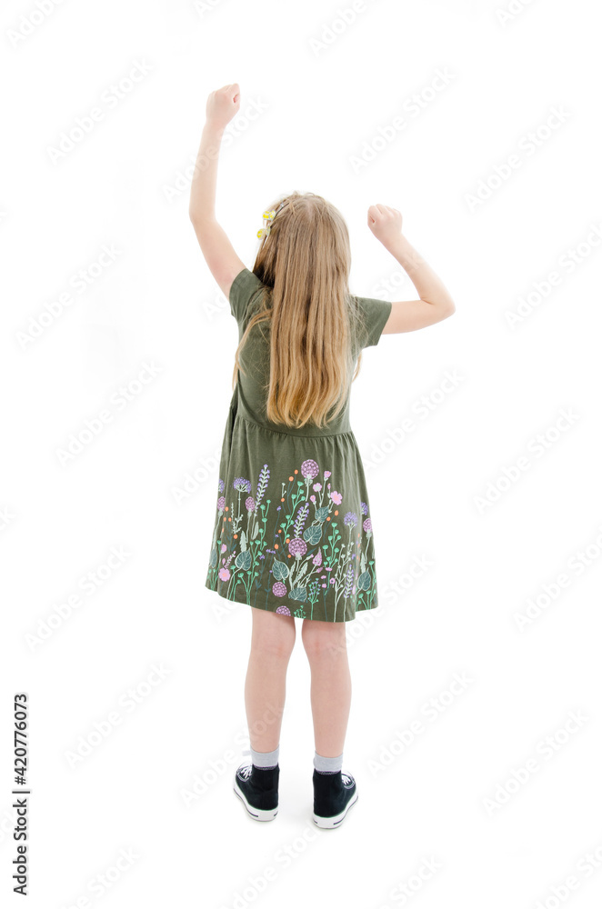 Back view of beautiful little girl in dress looking at wall and holds ...