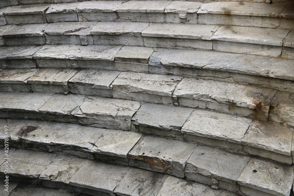 ancient and weathered stone steps of an old Roman amphitheater ...