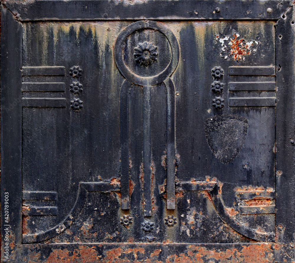 rusty ornate door of an industrial black metal box - worn steam punk ...
