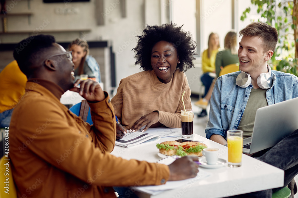 Cheerful group of college students having fun on lunch break in ...