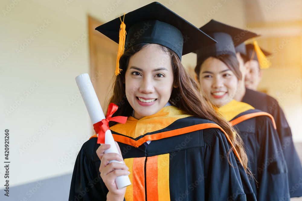 The Asian university graduates in graduation gown and a mortarboard cap ...