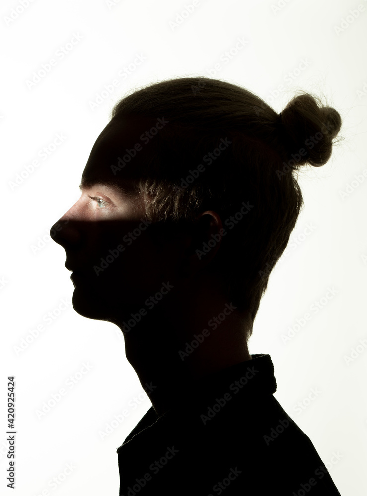 Head and shoulders portrait of teenage boy hidden in shadow, on white ...