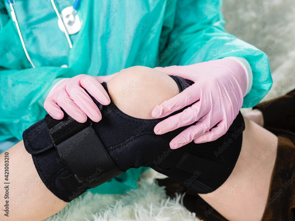 The doctor puts a brace on the injured knee. Rupture of the internal ...