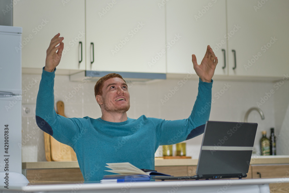 man at home laughing using laptop online, lucky winners. successful ...
