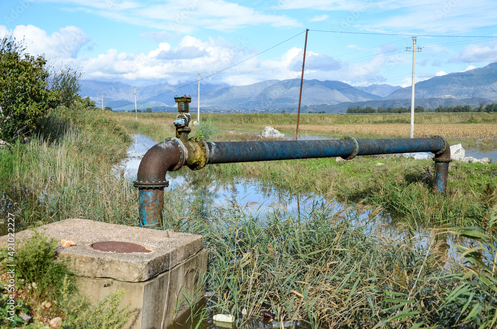 Rusty old water pipes and valves with wheels in nature. Rusted metal ...