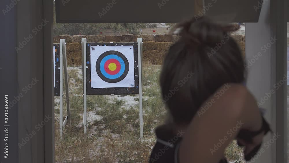 Archery target shooting. The back view of a woman who shoots an arrow ...