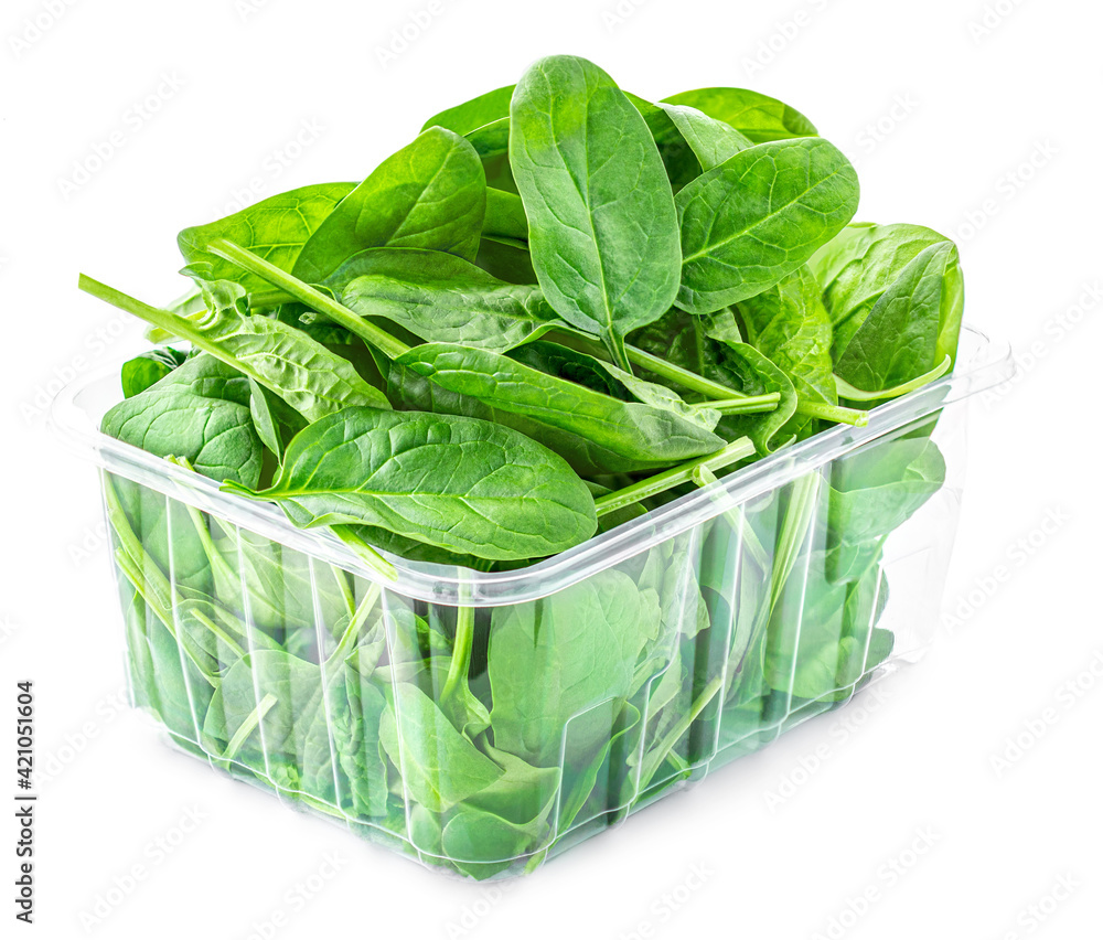 Spinach leaves in a plastic container isolated on white background ...