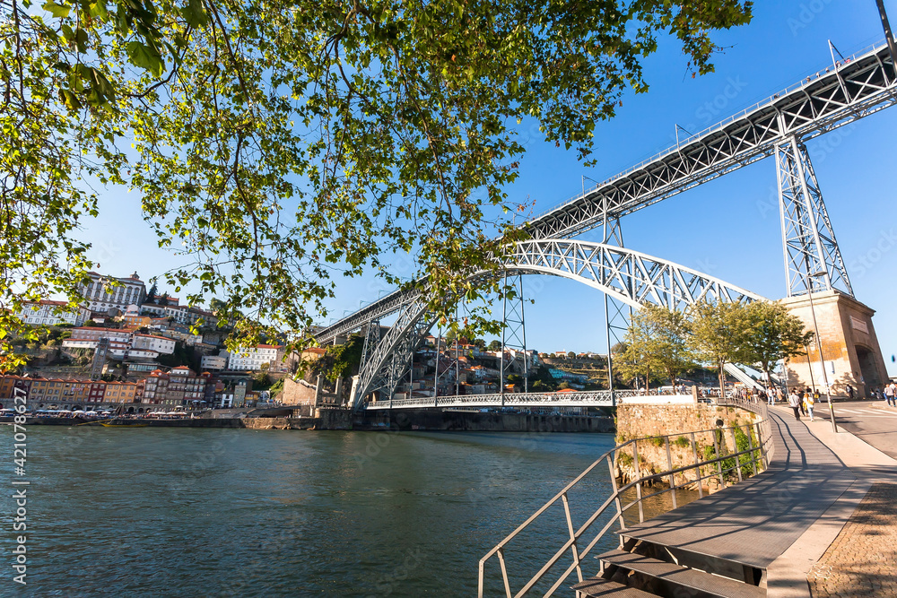 Riverfront and huge double-deck metal arch bridge in historical city ...