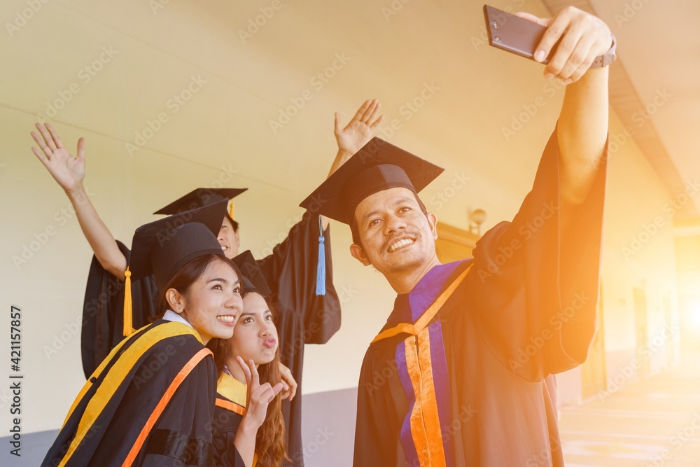 The university graduates in graduation gown and a mortarboard cap with ...