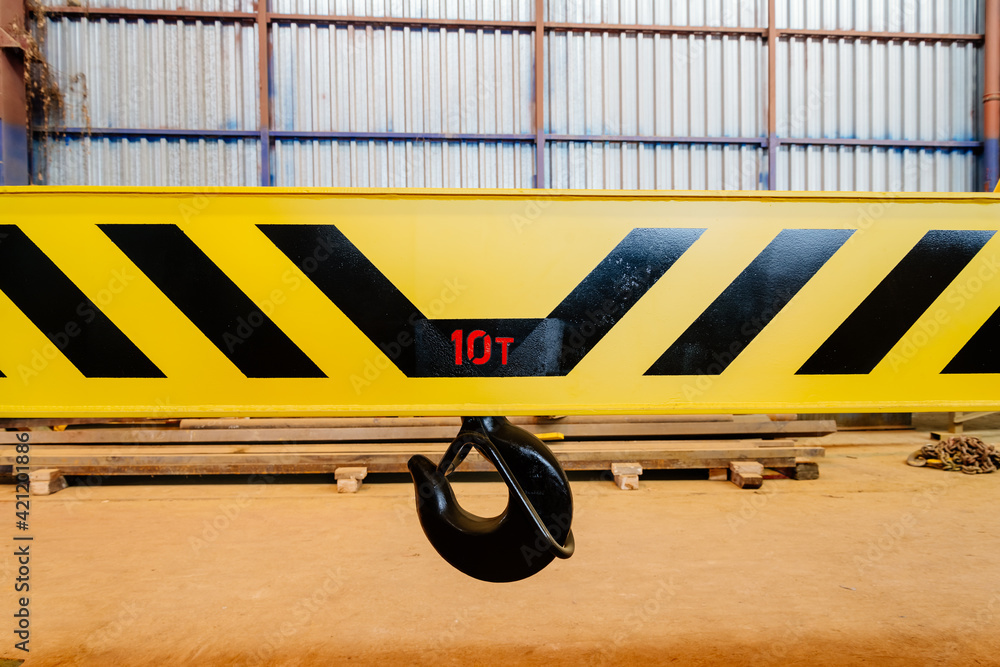 Crane hook on a yellow metal girder. Carrying capacity ten tons ...