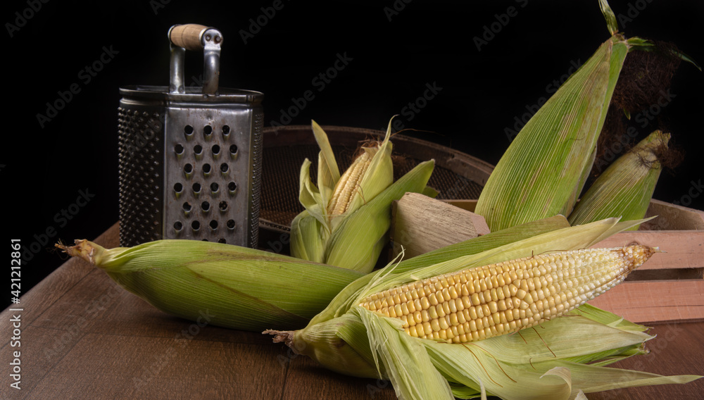 Festa Junina in Brazil, Green corn, grater and a sieve on a table ...