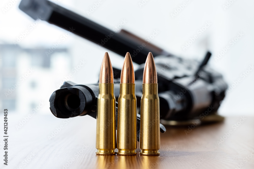 Three bullets against blurred Kalashnikov assault rifle background ...