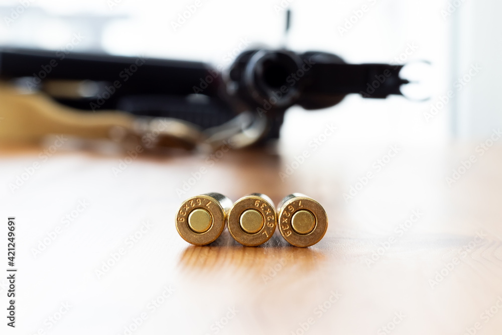Three bullets bottom against blurred Kalashnikov assault rifle ...