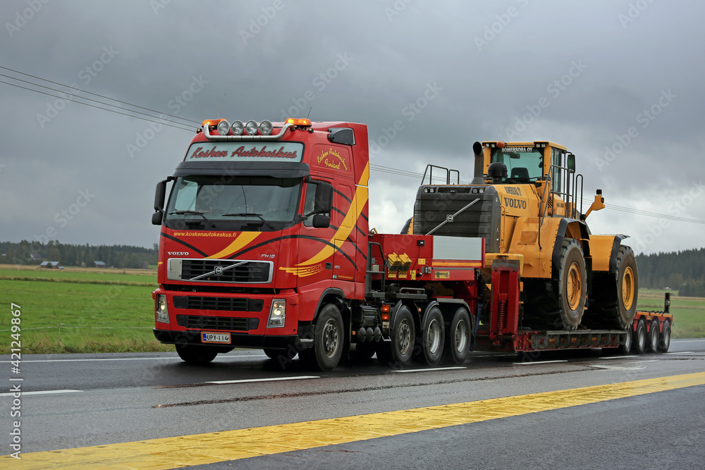 Volvo FH12 Hauls Wheel Loader as Oversize Load on Rainy Day Stock Photo ...