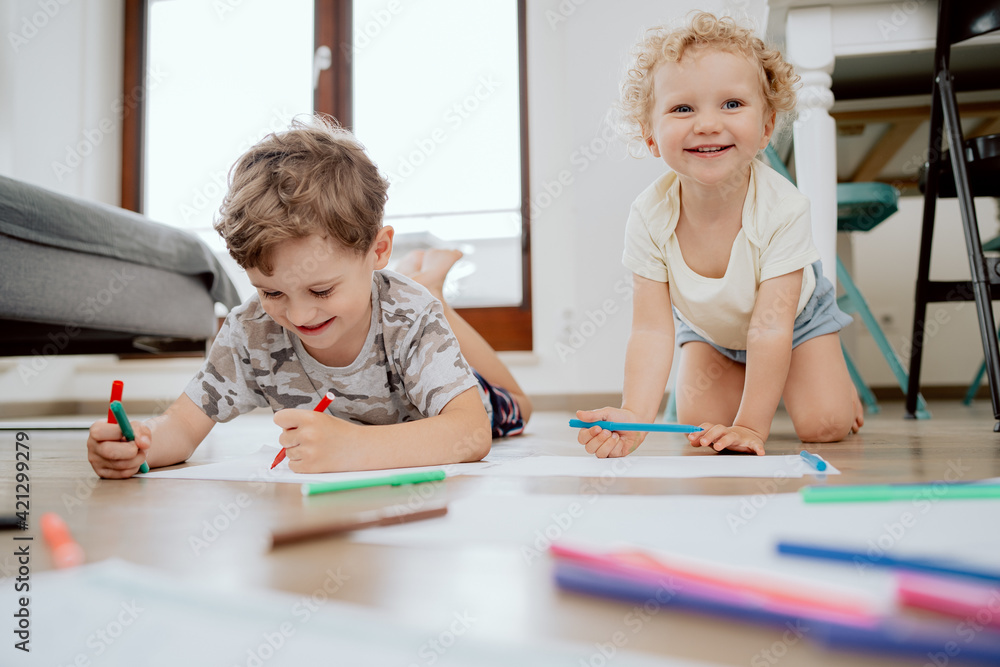 Foto de Little boy and girl draw together in white room with window ...