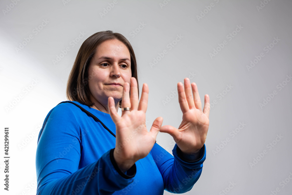 Portrait of a beautiful girl showing stop sign with palms isolated on a ...