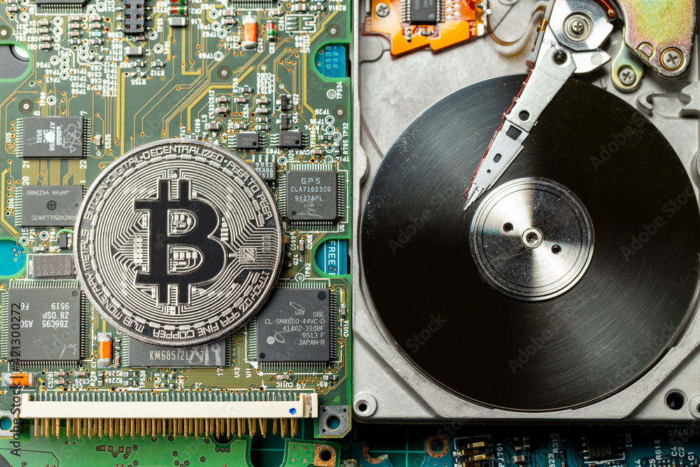 Token de criptomoeda Bitcoin prateada em cima de placas eletrônicas e ...