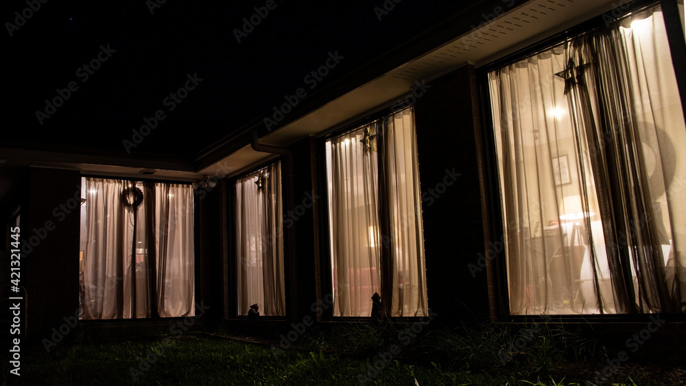 The light from windows of a house at night. View from outside. Stock ...