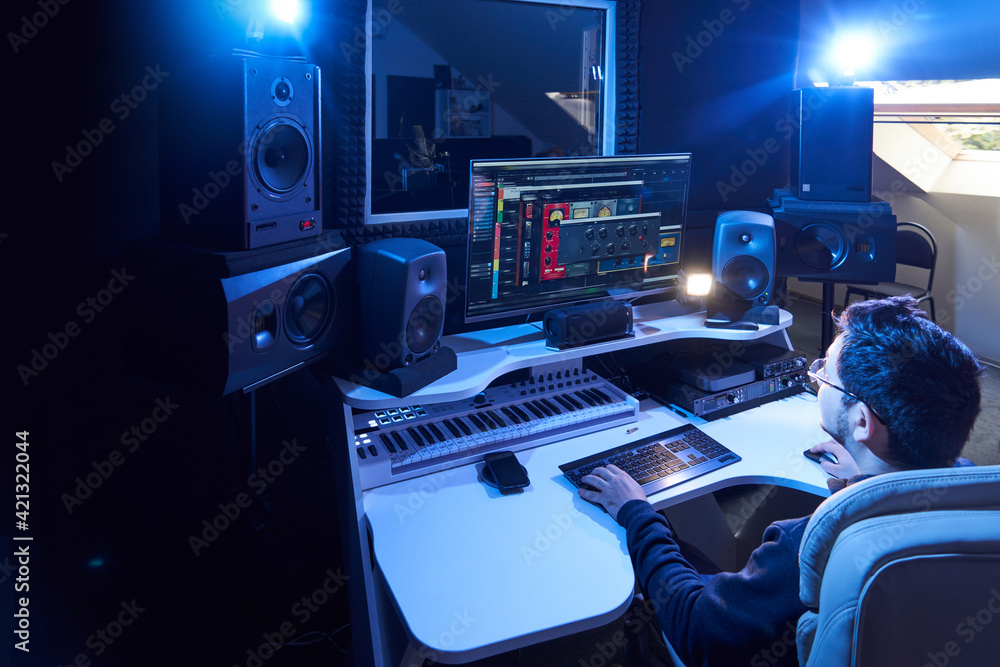 Foto de Professional male sound engineer mixing audio in recording ...