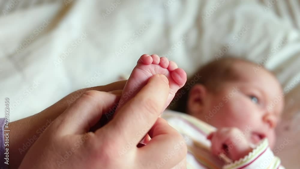 Demonstration of the baby's reflex. Mom presses her toe on the foot ...