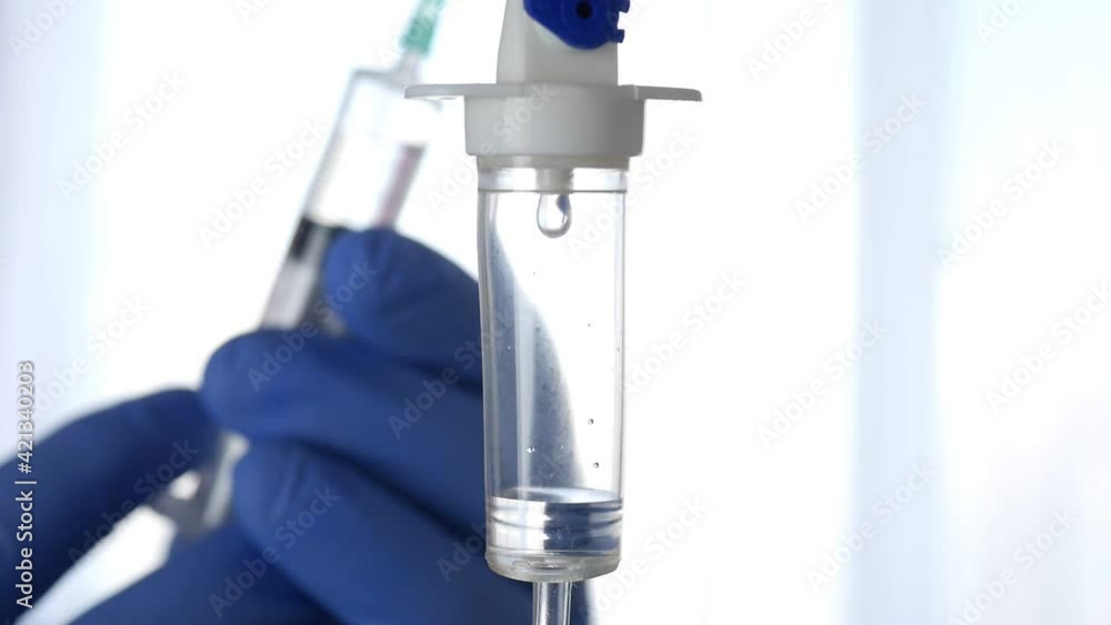 A Perfusion Dripping and a Doctor Preparing a Syringe with Vaccine ...