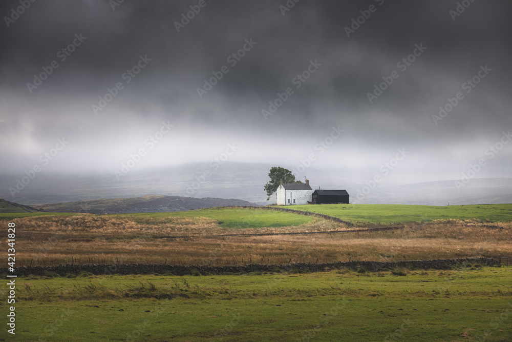 Lone, secluded farmhouse on a stormy, moody English countryside rural ...