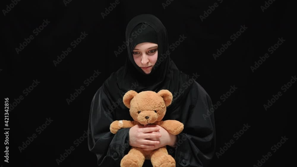 Middle shot portrait of shy Muslim woman in hijab posing at black ...