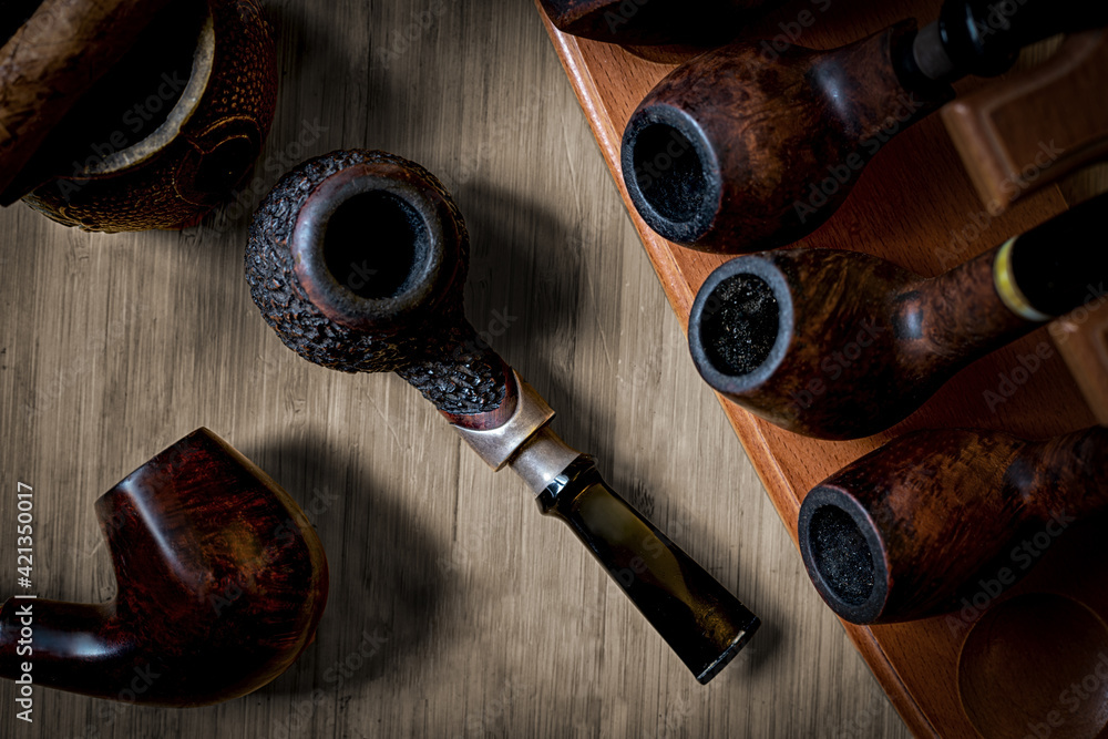 Smoking pipes of different shapes and types in a special rack. Stock ...