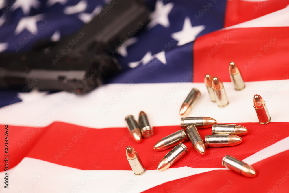 Many yellow 9mm bullets and gun on United States flag. Concept of gun ...