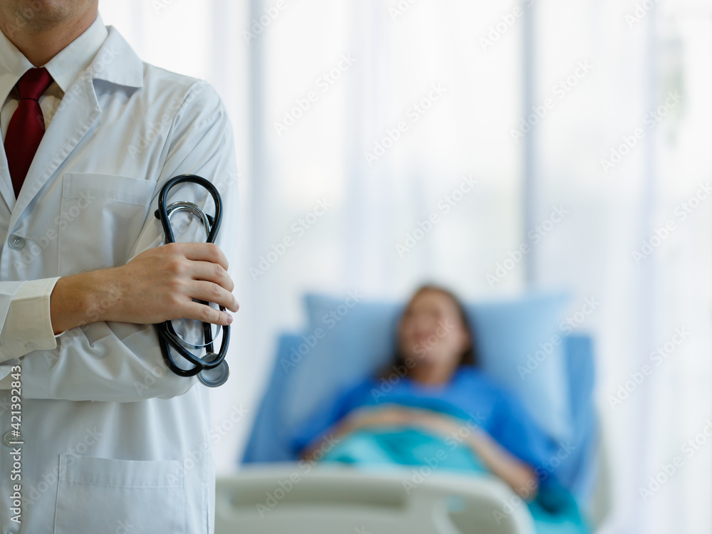Doctor wearing uniform holding stethoscope and background are blurry ...