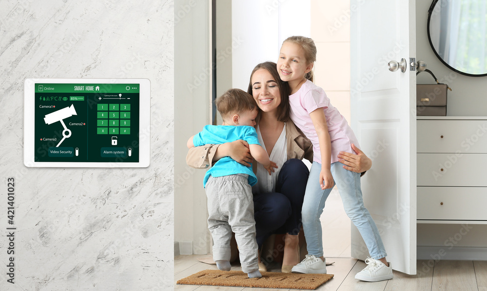 Happy children and their mother in hall under protection of smart home ...