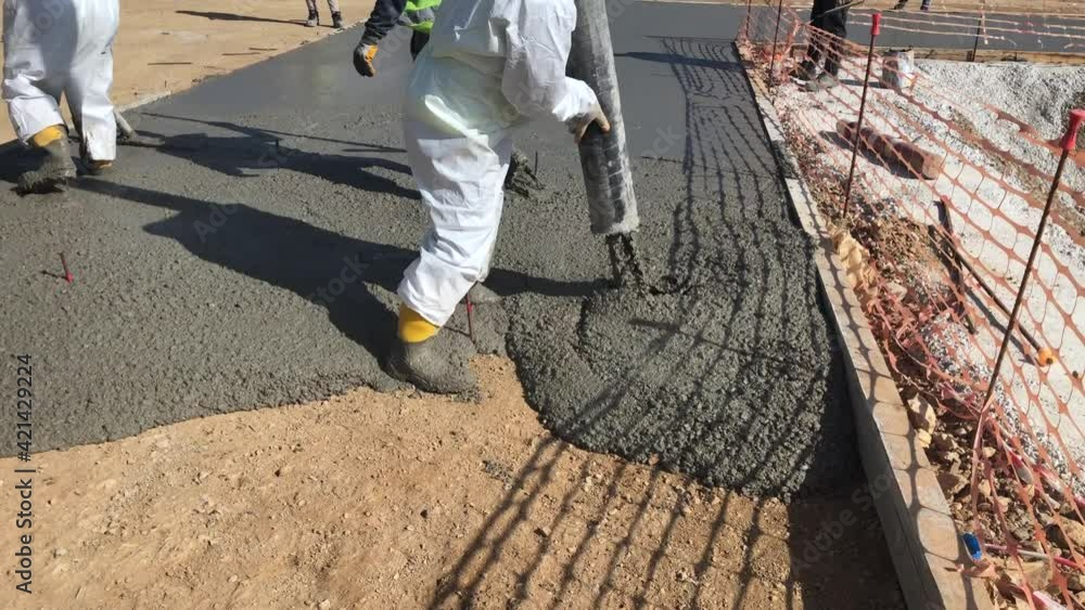 Construction workers are pouring concrete to formwork of cast in place ...