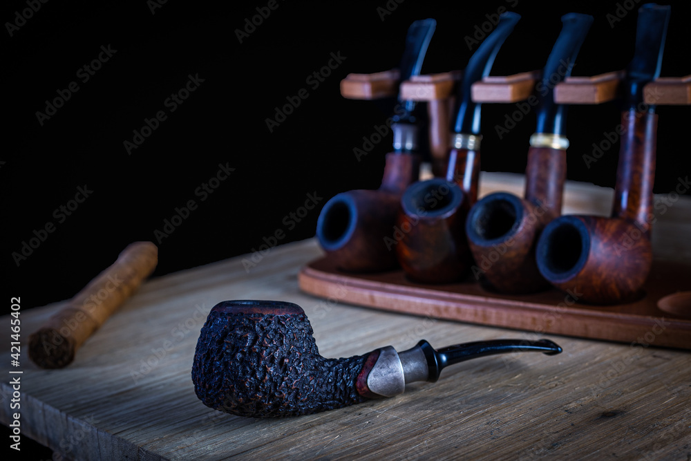 Smoking pipes of different shapes and types in a special rack. Stock ...