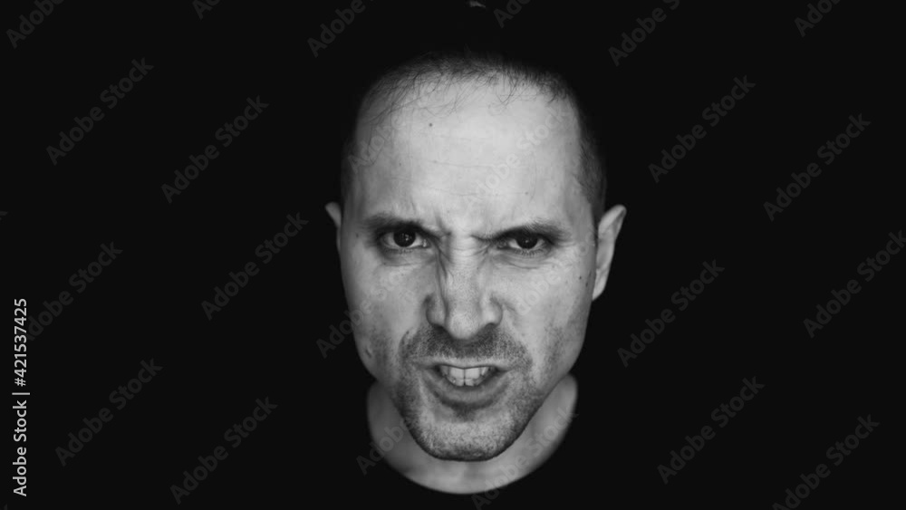 Aggression. A black-and-white photo of an angry man. He grins. The ...