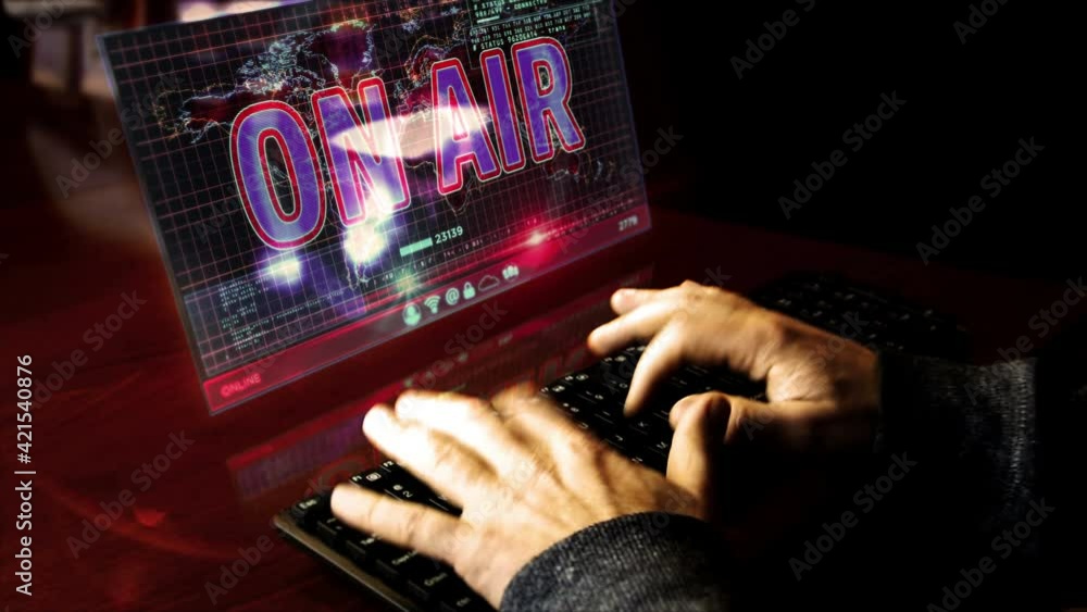 Hacker typing on the keyboard with On Air on virtual display on desk ...