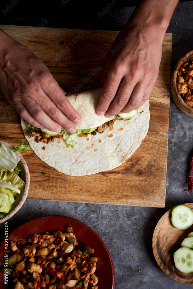Photo & Art Print young man rolls a durum or a burrito, nito