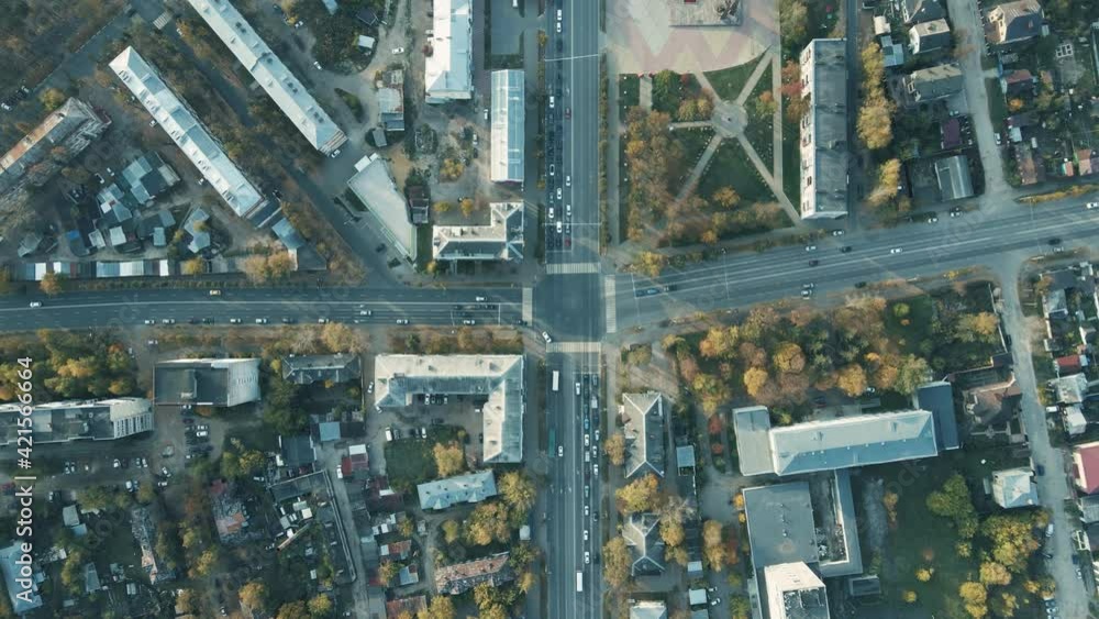 A wide city road intersection in the morning there are many cars. The ...