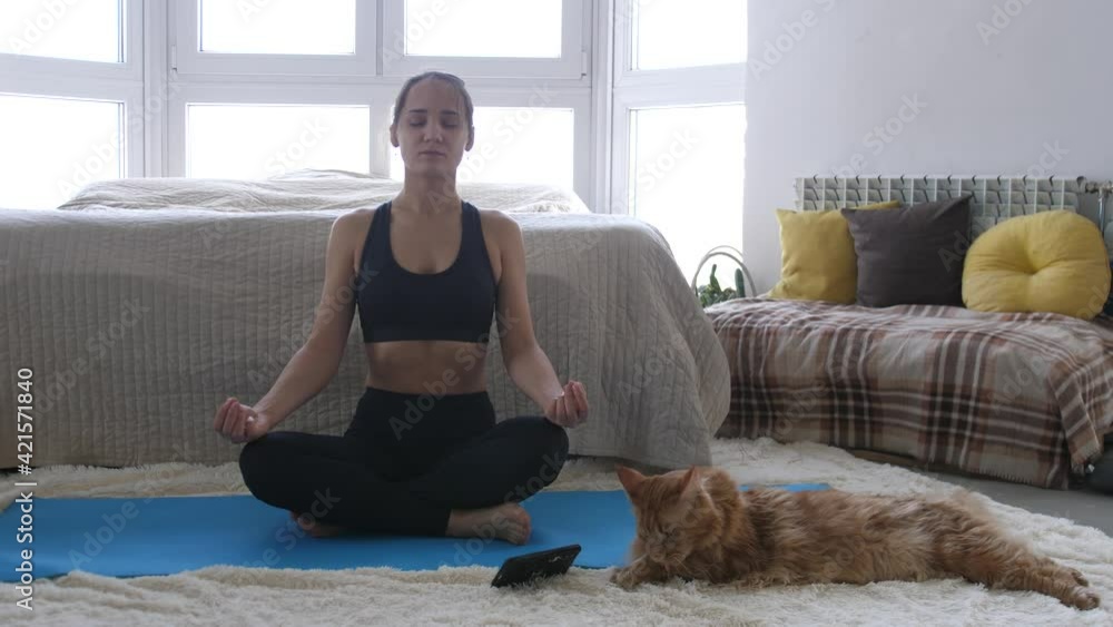 Young woman blogger shoots video doing Yoga exercise with phone while ...