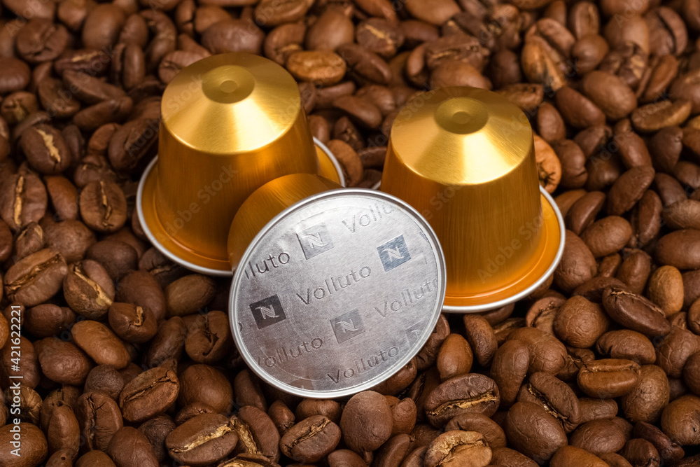 Three nespresso coffee capsules on coffee grain background. Taste ...