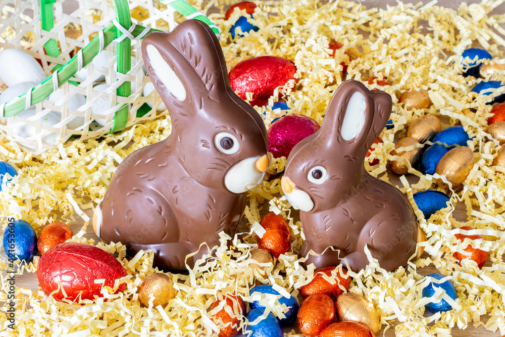 Pâques. Deux lapins en chocolat au lait sur de la paille. Paniers avec ...