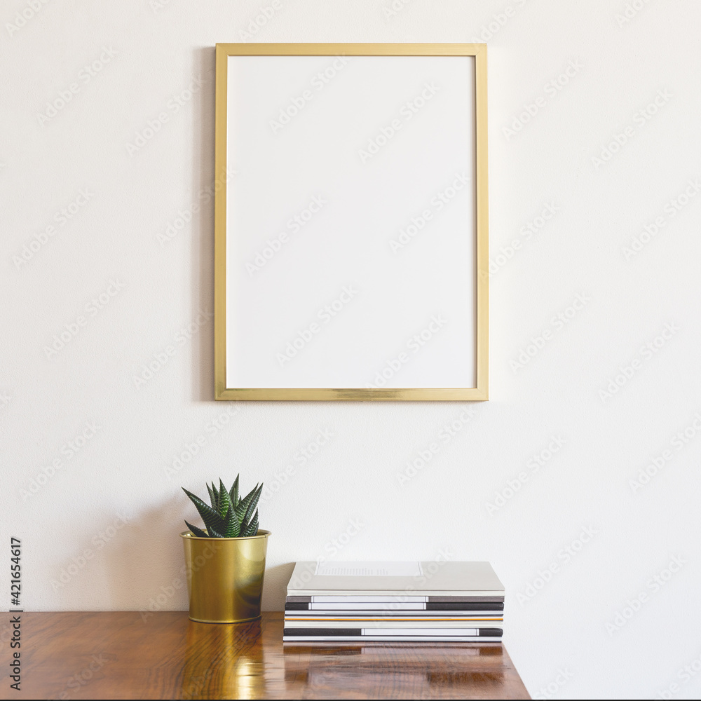 Gold frame over a wood desk with magazines and plant. Mock-up. Stock ...