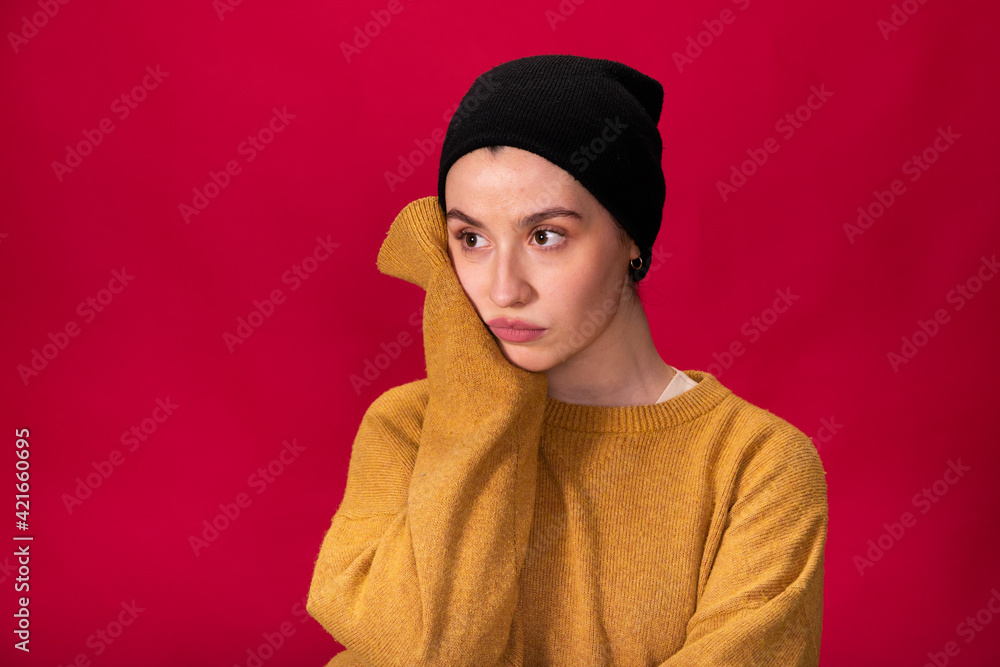 brunette hipster girl in black knitted cap and mustard sweater thinking ...