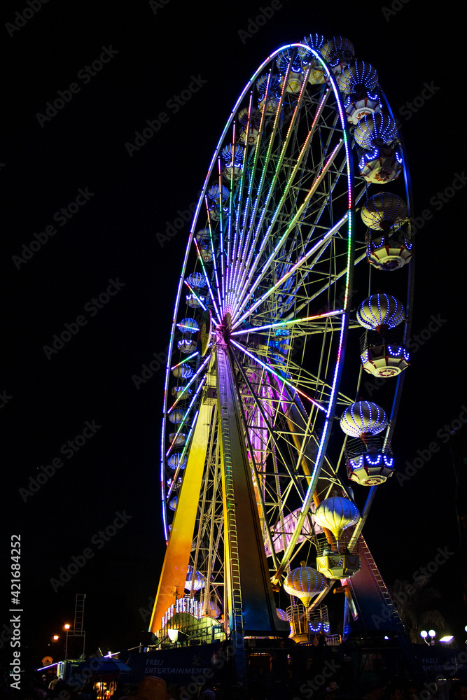 Rueda de la fortuna en una feria de pueblo de noche con luces de ...