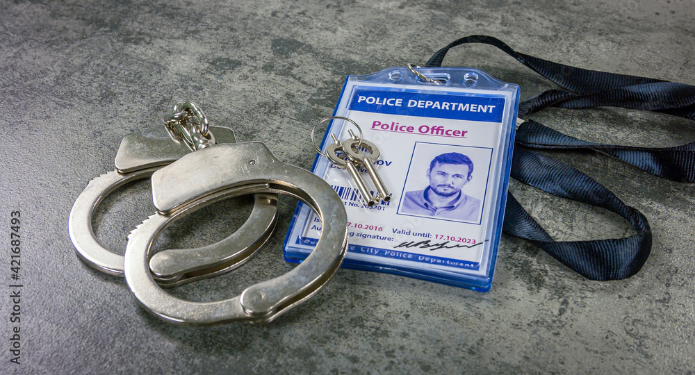 Handcuffs and police access pass as symbols on a concrete surface Stock ...